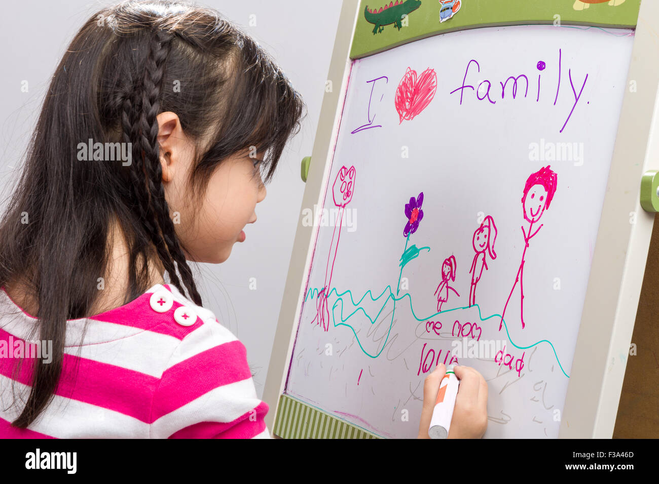 Kid drawing her family picture on whiteboard Stock Photo - Alamy