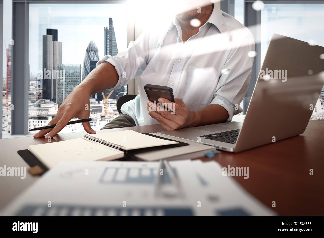 designer hand working and smart phone and laptop on wooden desk in ...
