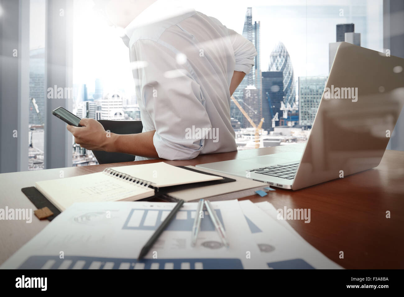 designer hand working and smart phone and laptop on wooden desk in ...