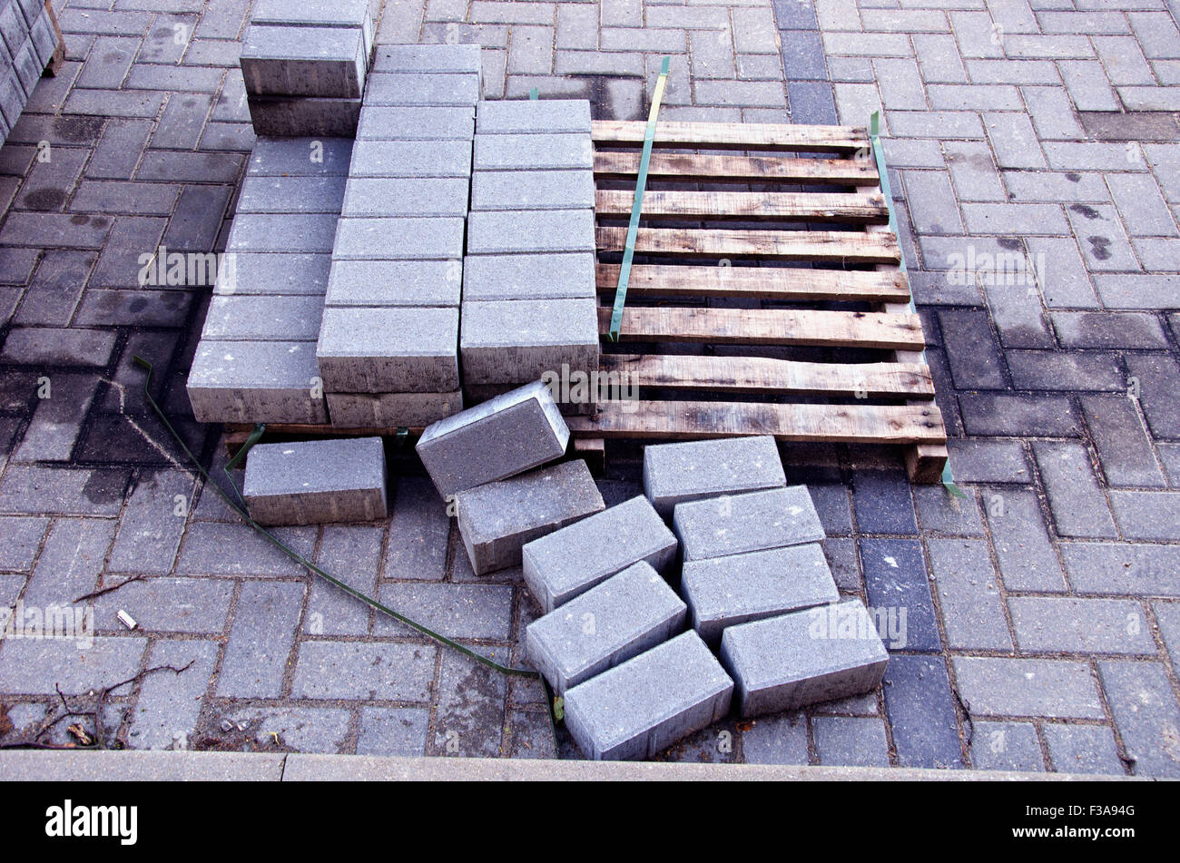 Pallet with few rows of concrete grey pavement blocks bricks in street ...