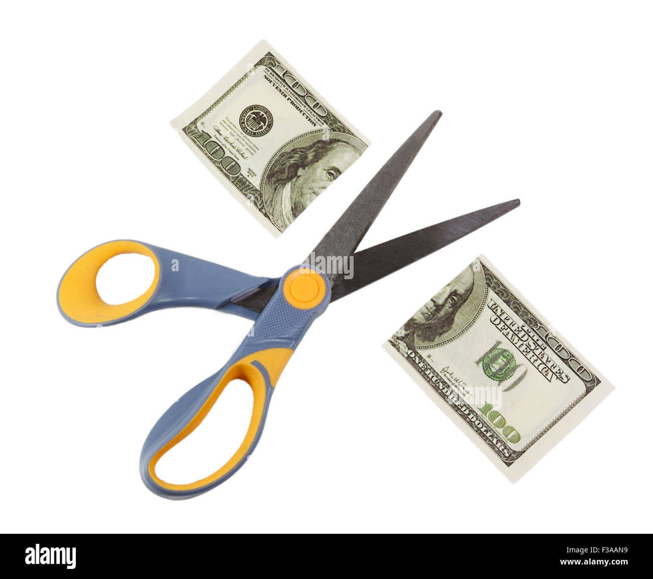 scissors cut a hundred dollar bill in half isolated on white background ...