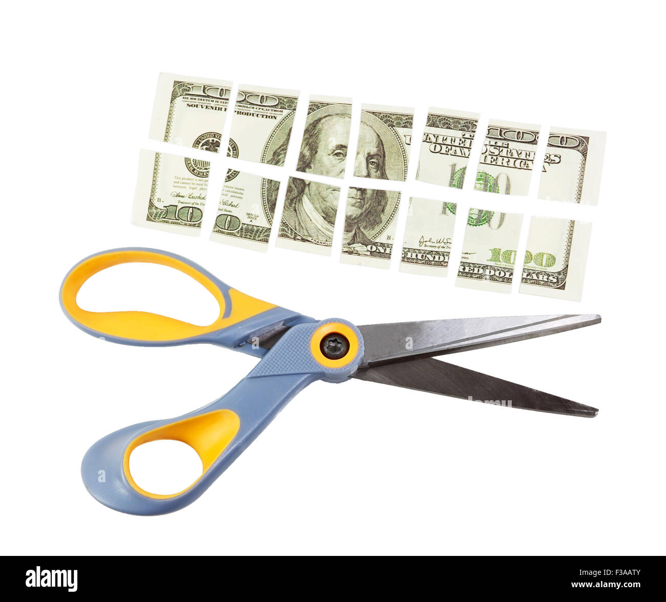 scissors cut a hundred dollar bill into many parts isolated on white ...