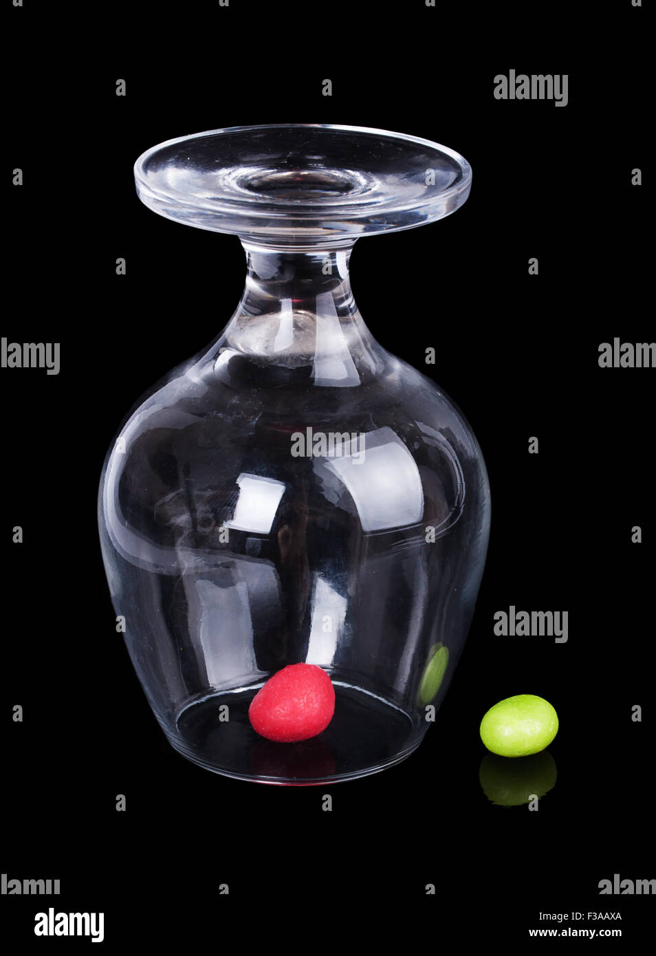 red small stone under an inverted glass isolated on a black background ...