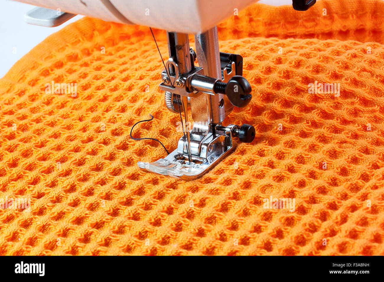 sewing machine working part with orange cloth Stock Photo - Alamy