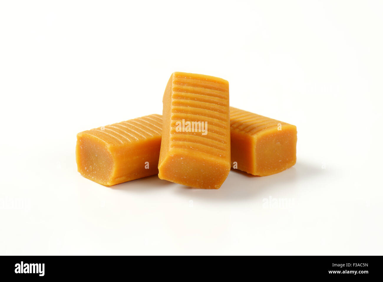 three caramel toffee candies on white background Stock Photo - Alamy