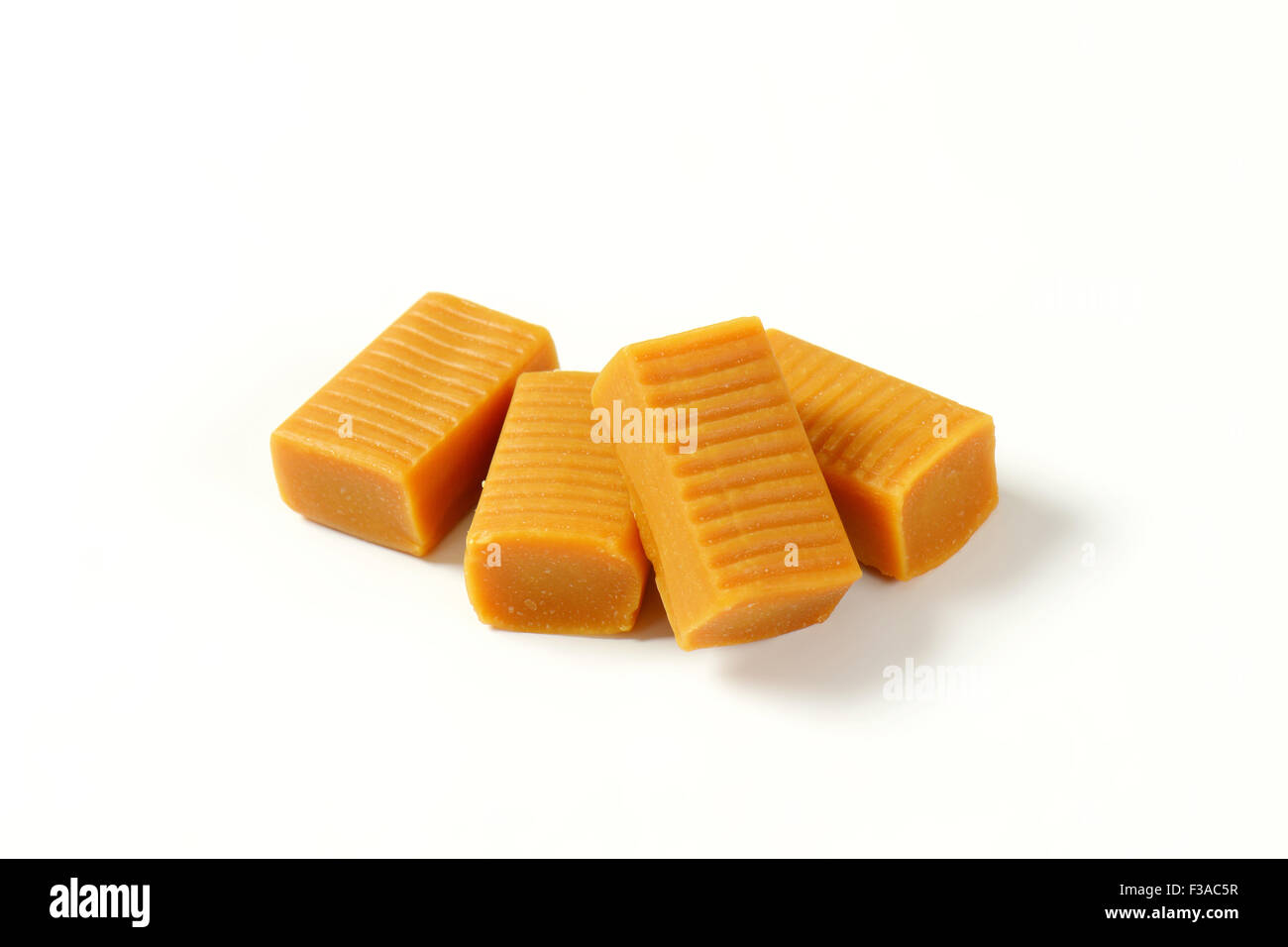four caramel toffee candies on white background Stock Photo - Alamy