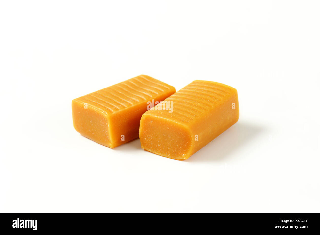 two caramel toffee candies on white background Stock Photo - Alamy