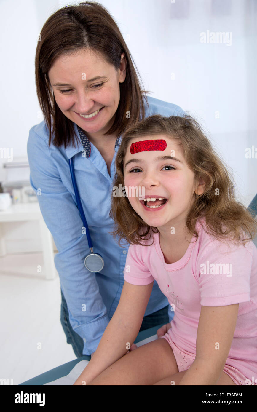 MODEL RELEASED. Young girl with a plaster on her forehead, laughing ...