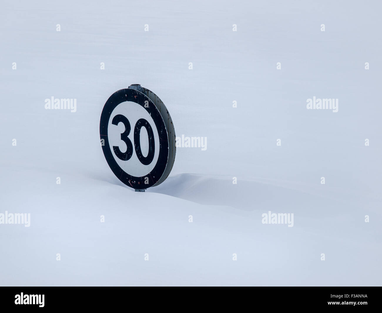Speed restriction road sign buried in snow drift, Norway Stock Photo ...