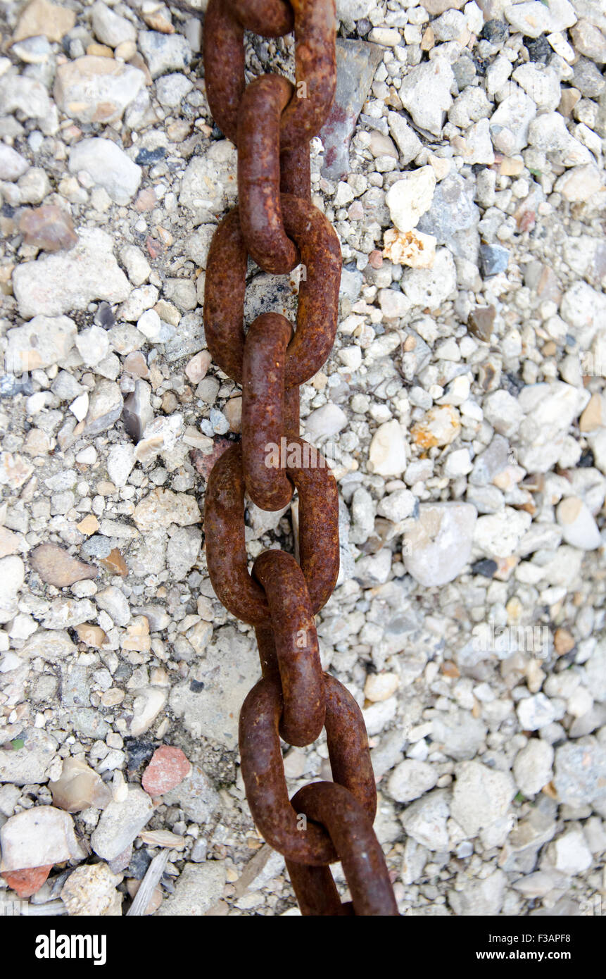An ancient rusty chain with rocks background Stock Photo - Alamy