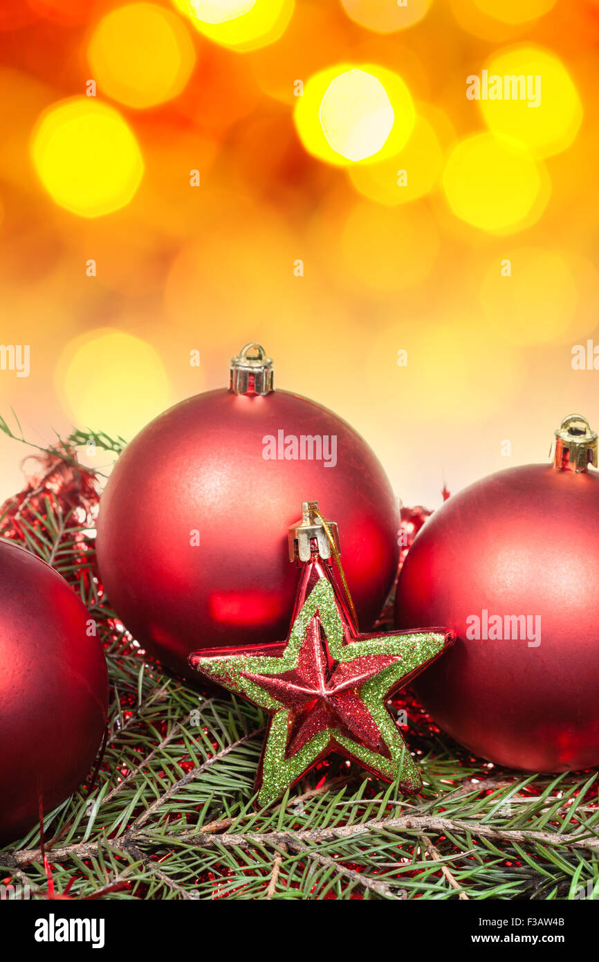 Xmas still life - red baubles, star, green tree with blurred yellow ...