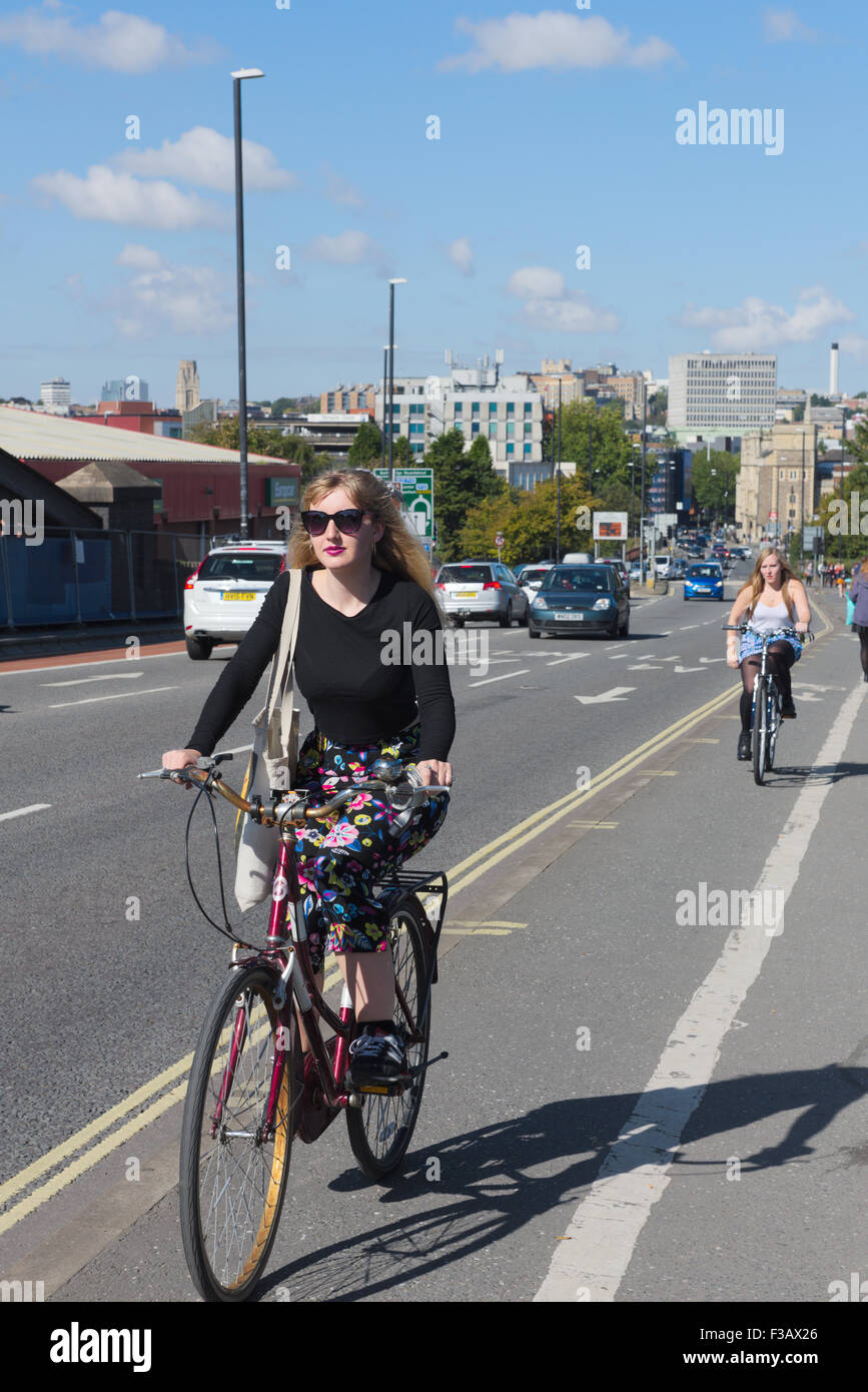 Woman cyclist riding along bike path on pavement Stock Photo - Alamy