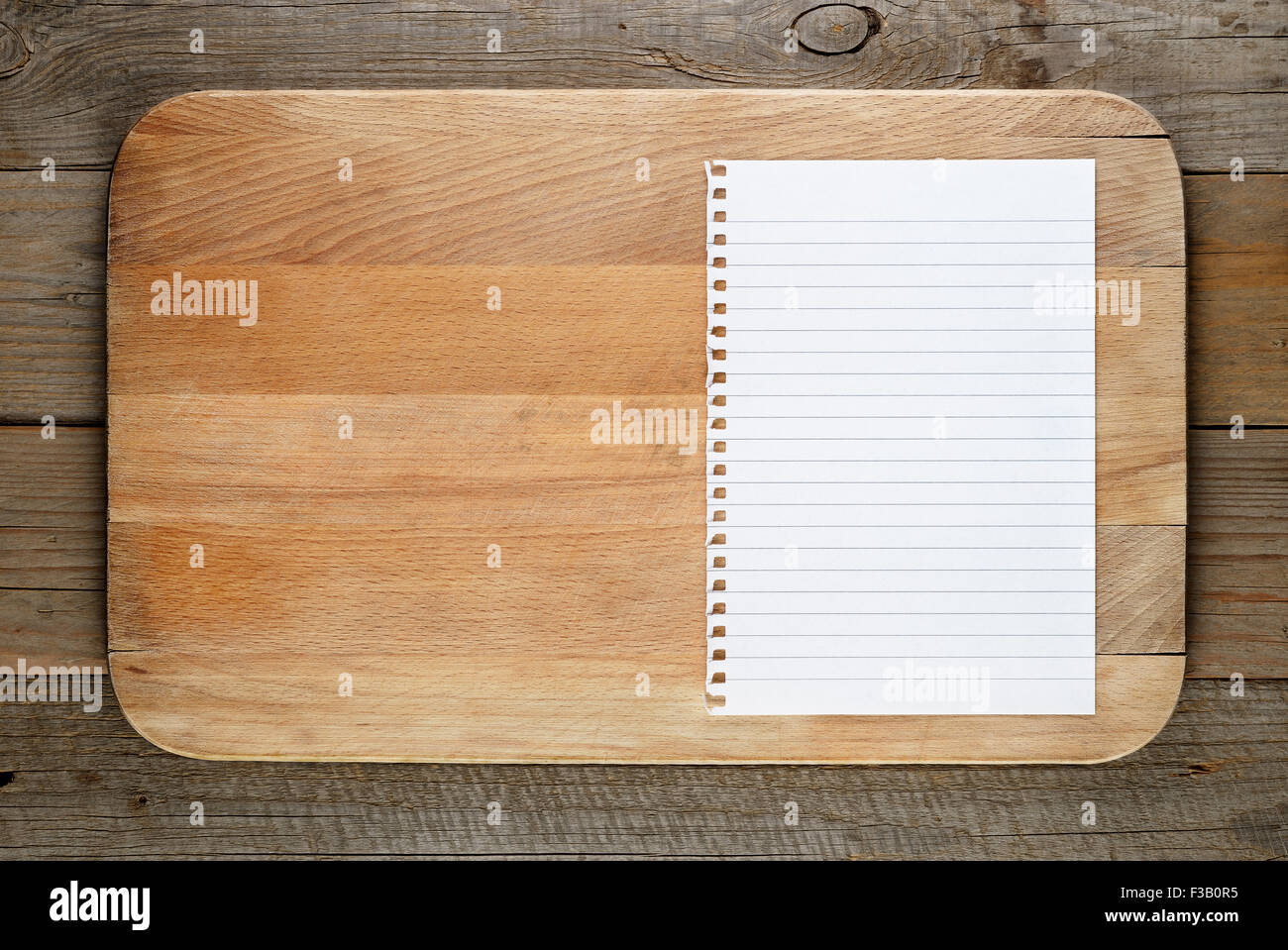 Chopping board and paper for recipe on wooden background Stock Photo ...