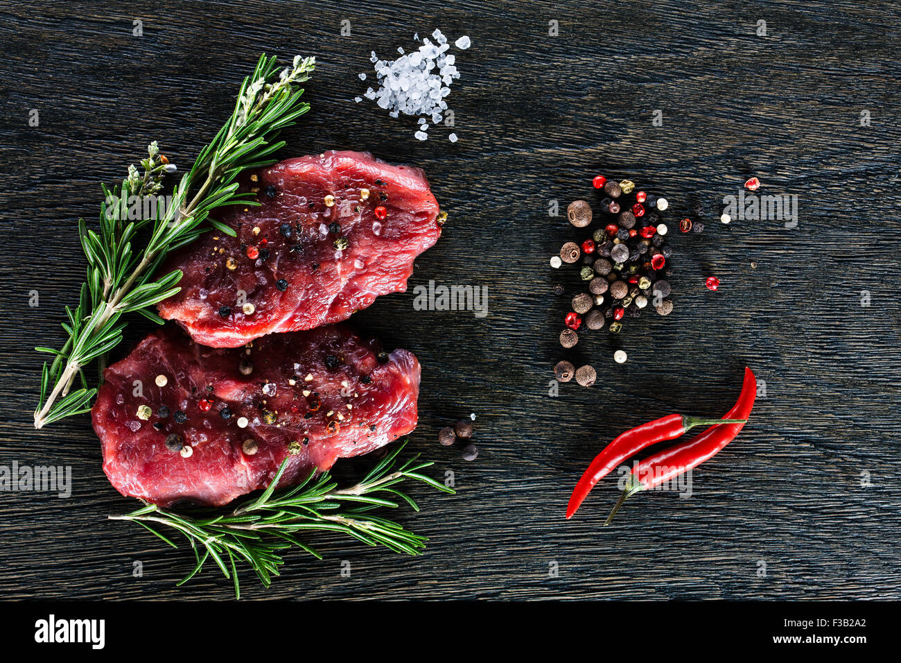 Two beef steaks garnished with a couple of rosemary twigs, dwarf chili ...
