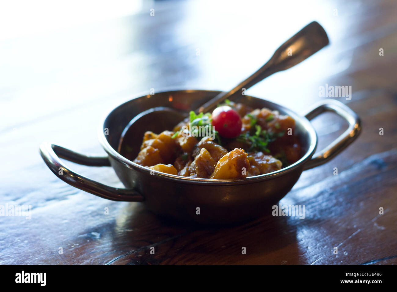 Indian vegetarian dish Jeera Aloo or Indian potatoes topped with tomato ...