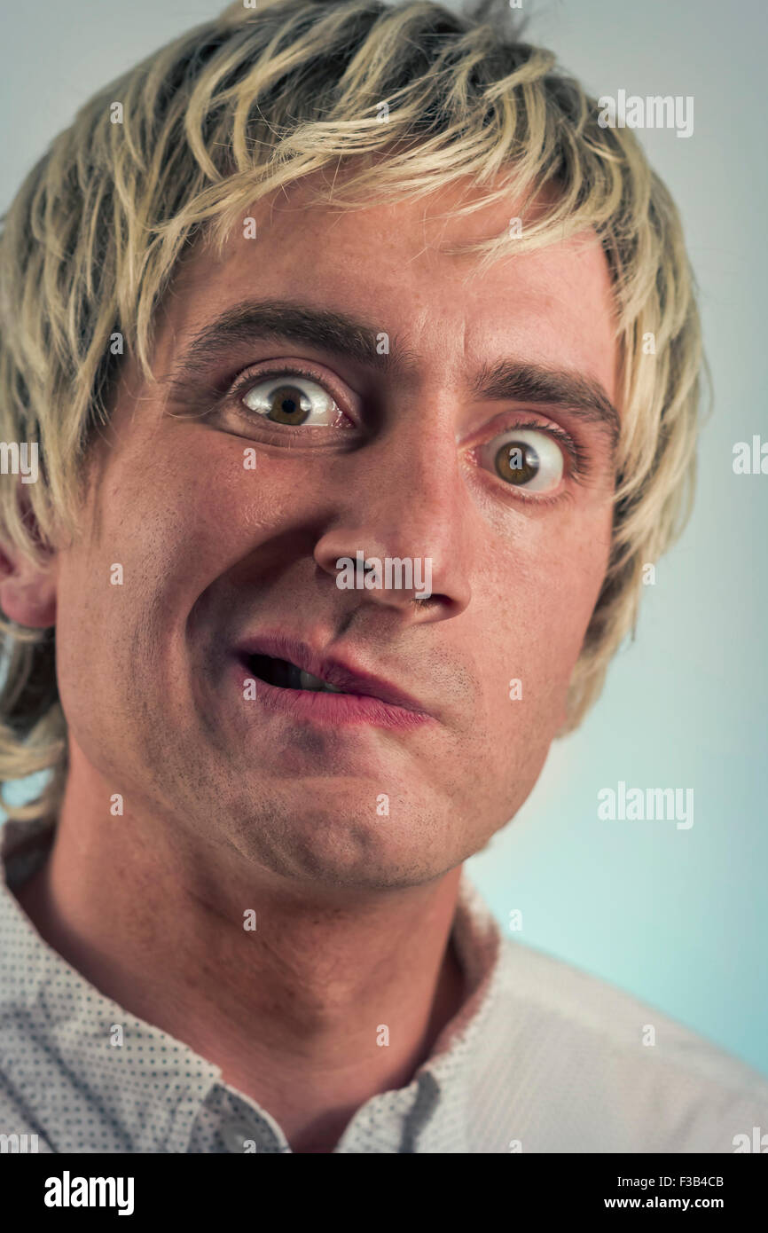 Angry blonde haired man growls from one side of his mouth Stock Photo ...