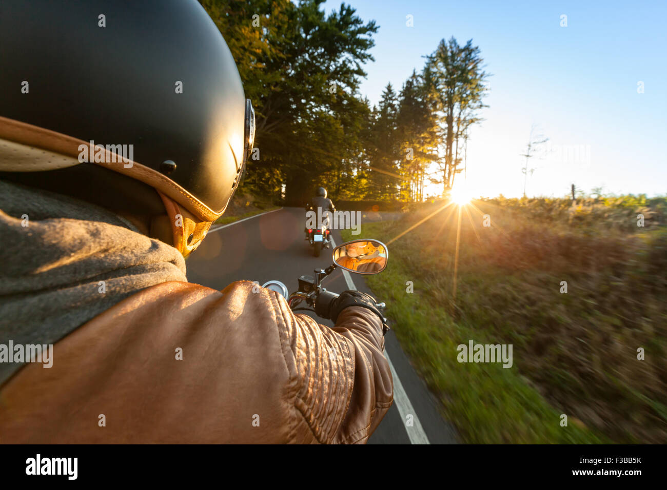 Biker riding motorcycle in sunny morning Stock Photo - Alamy