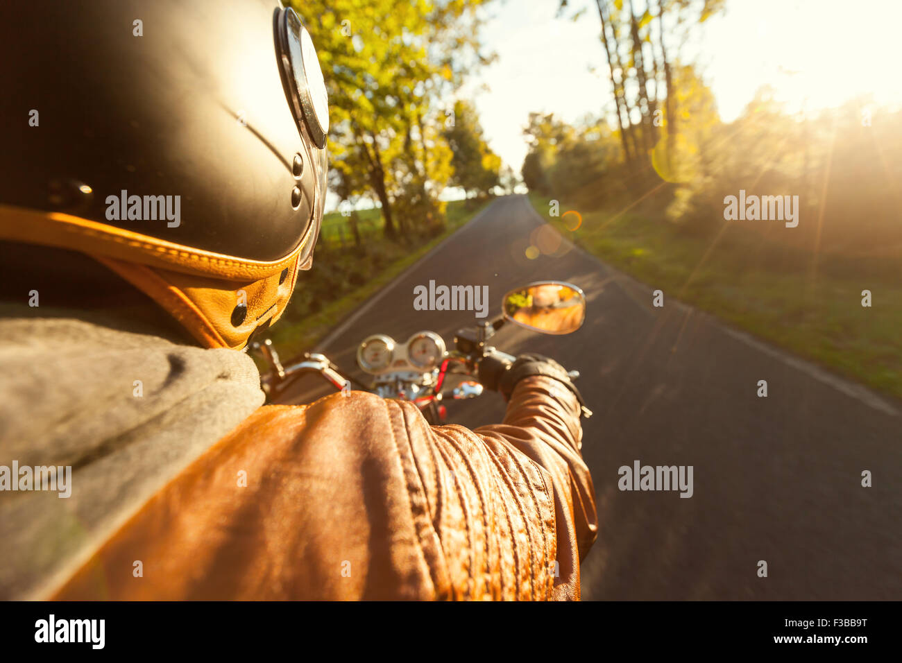 Biker riding motorcycle in sunny morning Stock Photo - Alamy