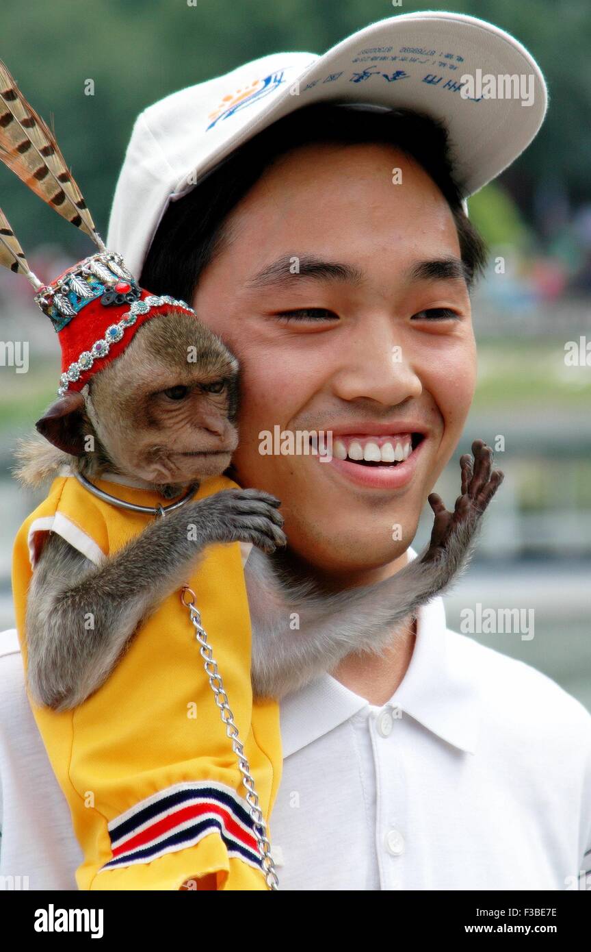Guilin, China: Young Chinese man posing with a costumed monkey at ...