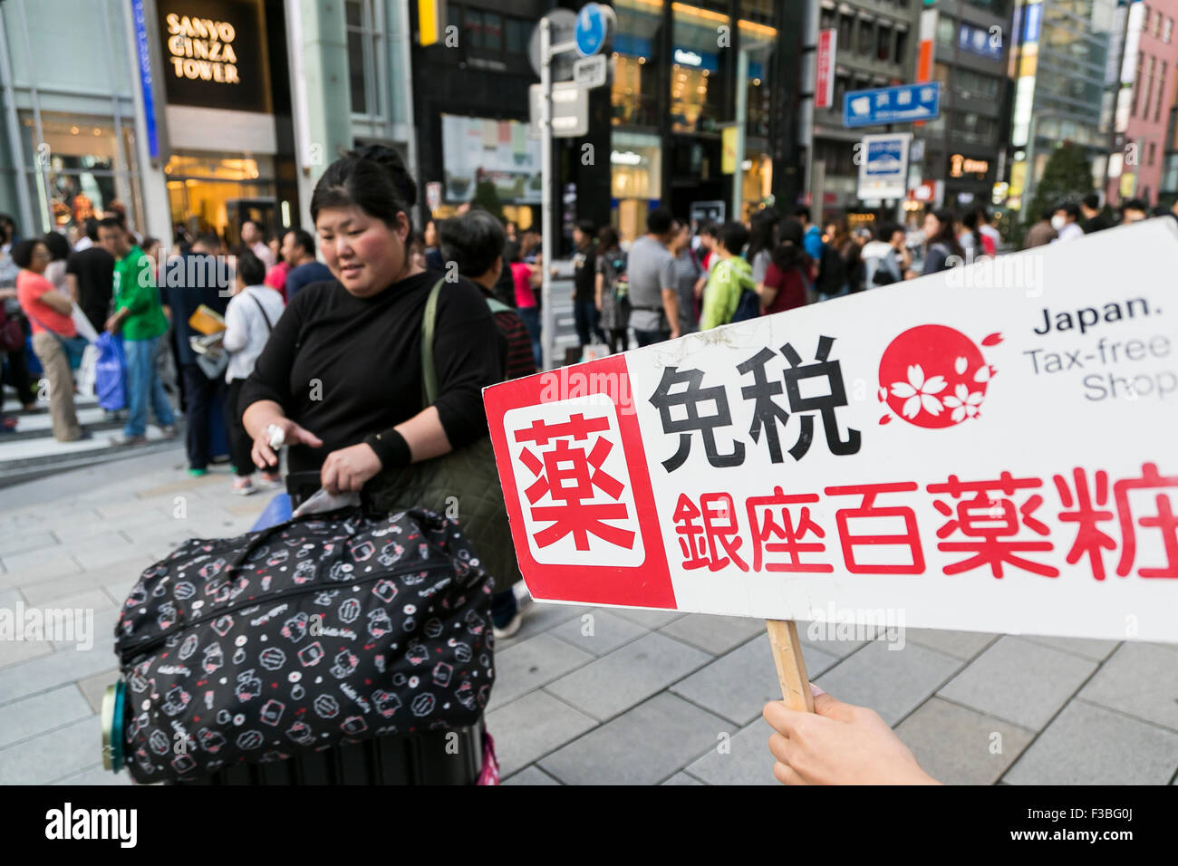 Chinese tourists walk past luxury shops in Ginza shopping district ...