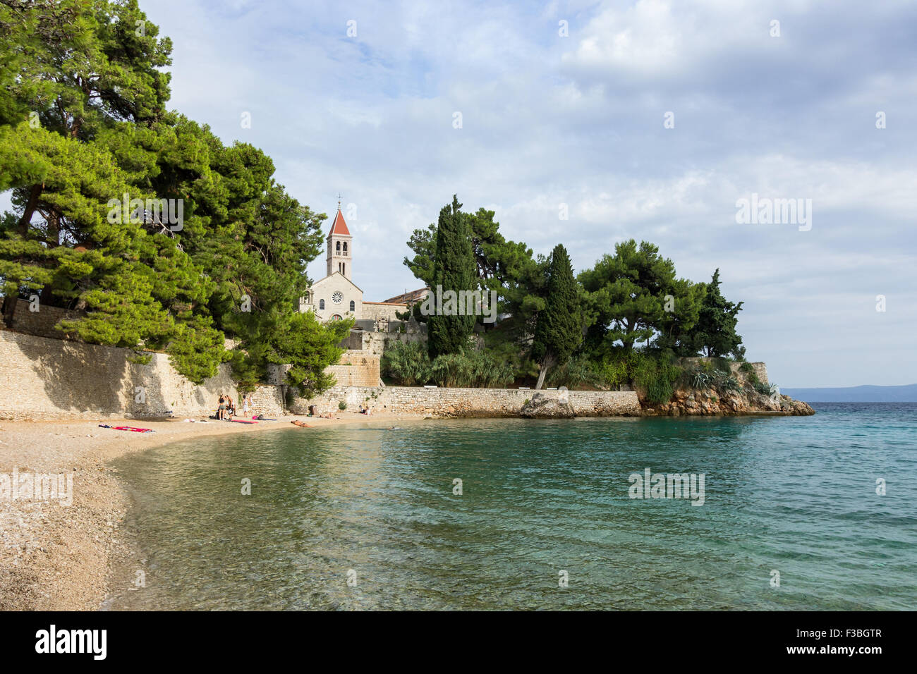 Small and tranquil beach in Bol, Croatia. Small church of St. Ivan and ...