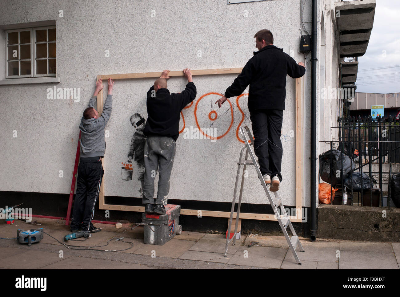 Workmen covering up the Banksy graffiti for Daniel Halpin aka Tox ...