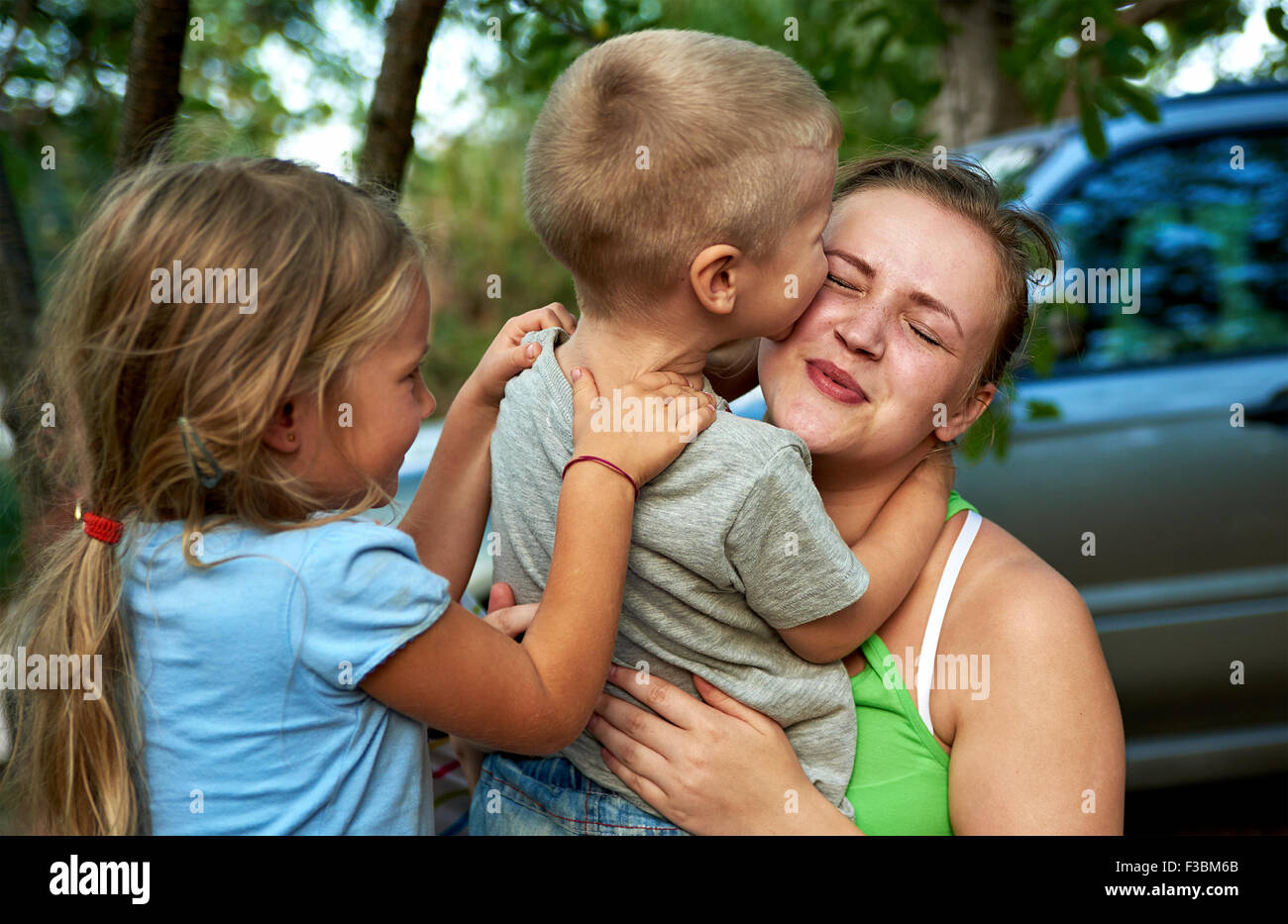 Happy Mother and children embracing hugging outdoors Stock Photo - Alamy