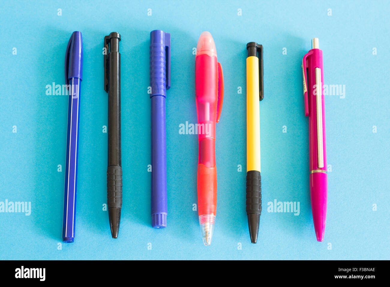 Colourful pens on a blue background Stock Photo - Alamy