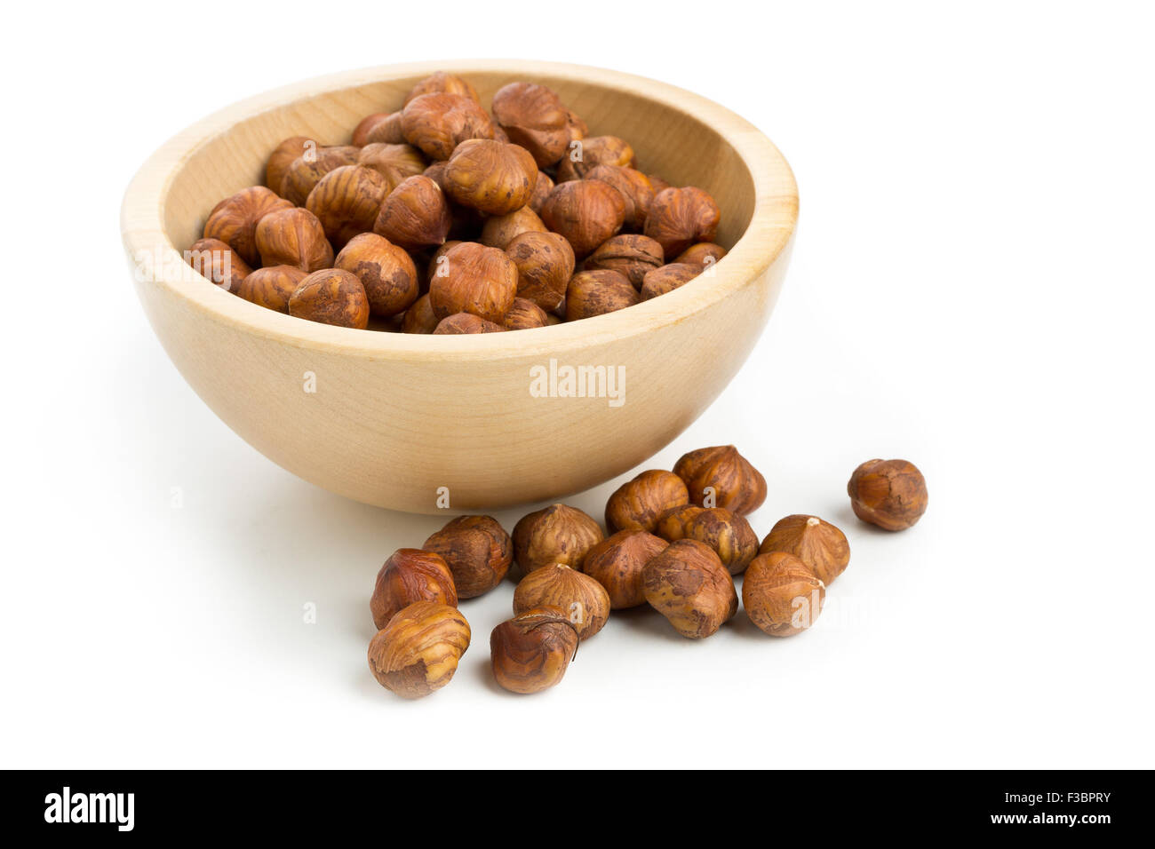 Pile of cracked and shelled hazelnut kernels in wooden bowl on white ...