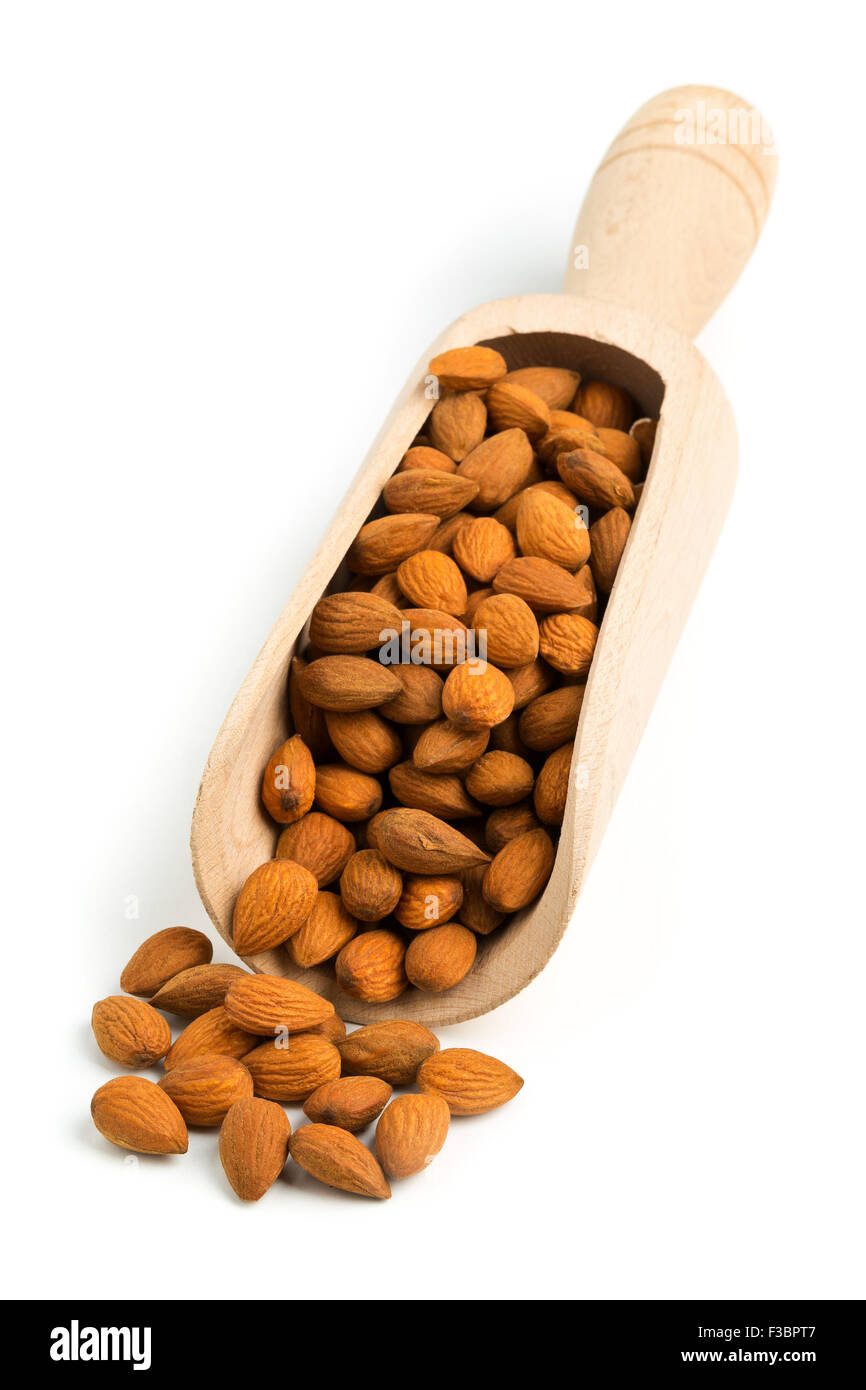 Pile of cracked and shelled almond kernels in wooden scoop on white ...