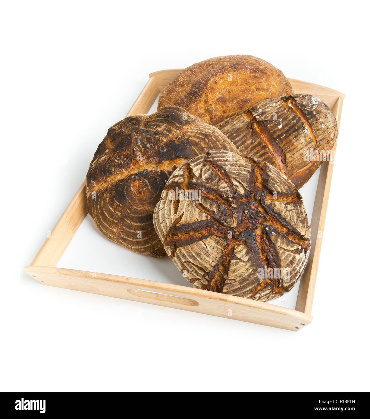 Four different hand-made bread loaves on serving tray isolated on white ...