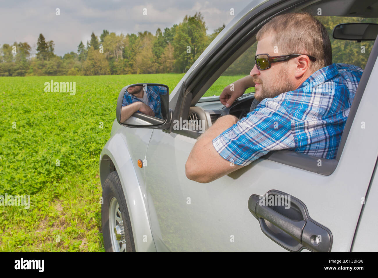 Man sitting in a car on driver's place and looking forward Stock Photo ...