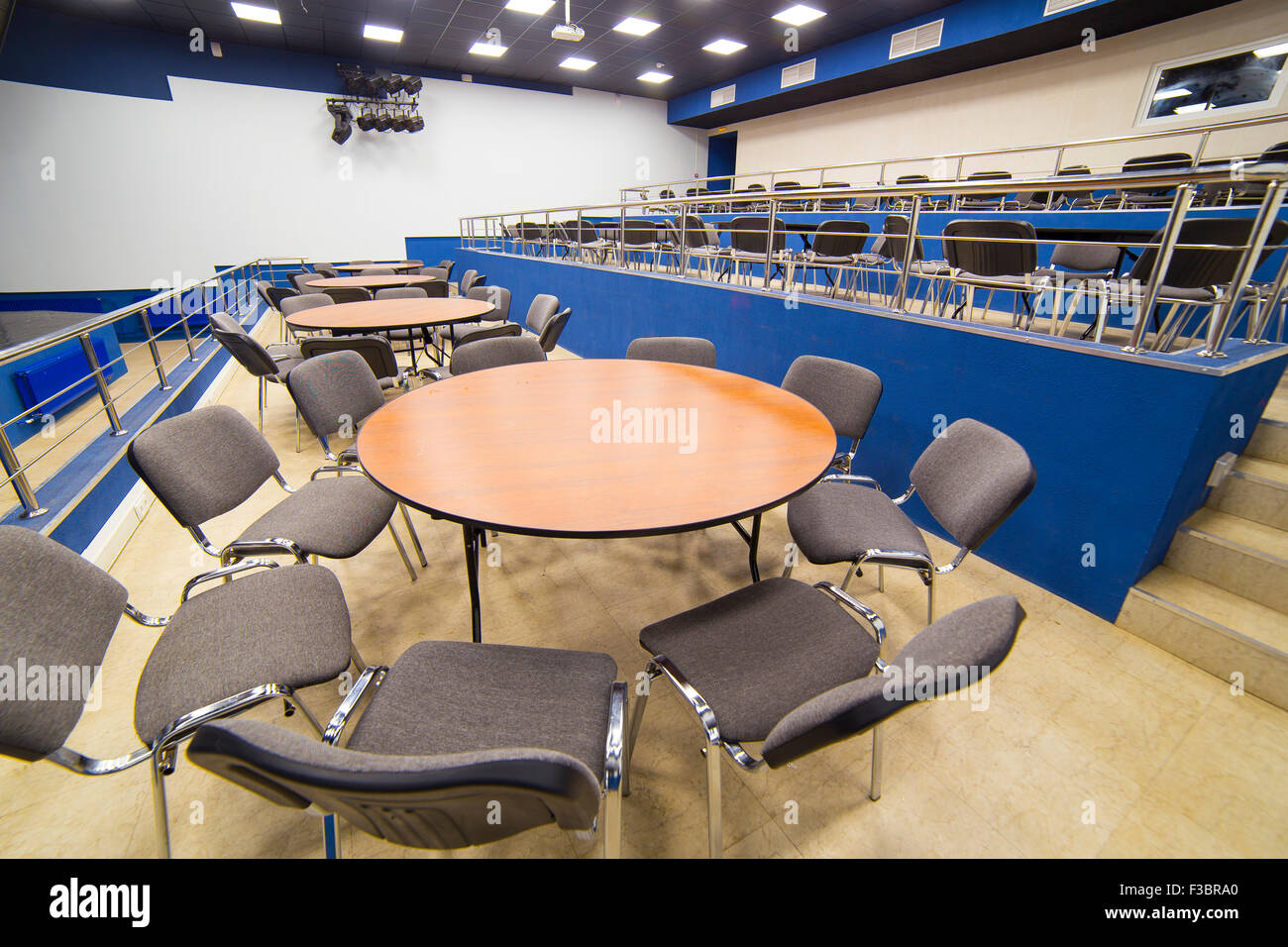 Empty conference hall with round tables and chairs Stock Photo - Alamy