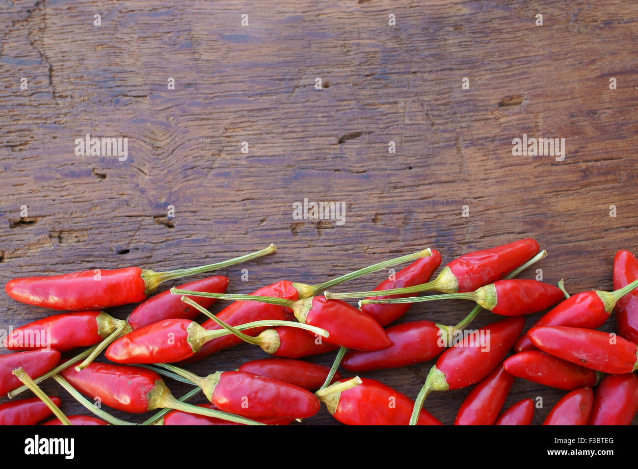Fresh hot red chili peppers with border at the lower side as a frame on ...