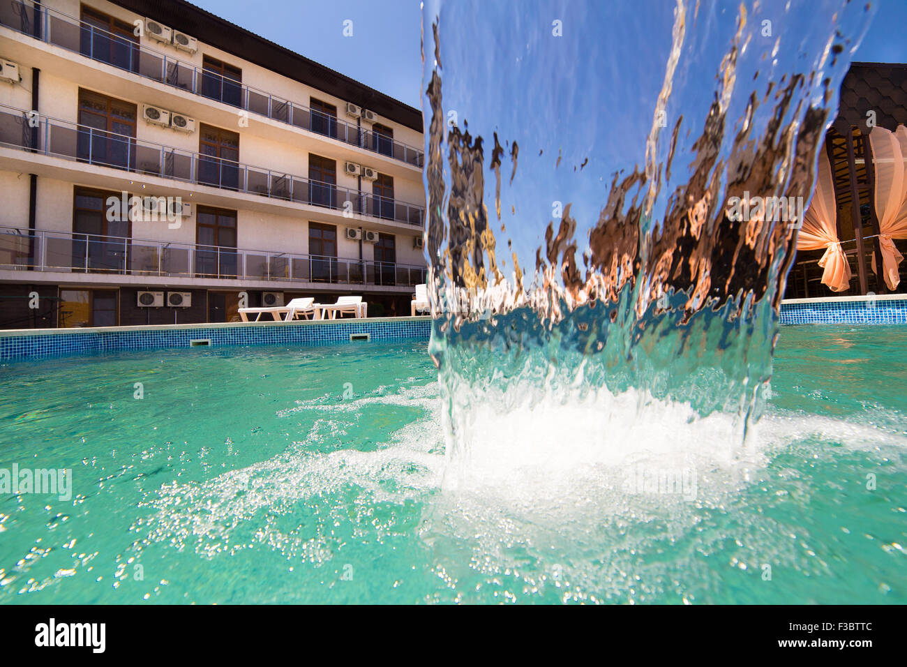 Hotel open air swimming pool with waterfall Stock Photo - Alamy