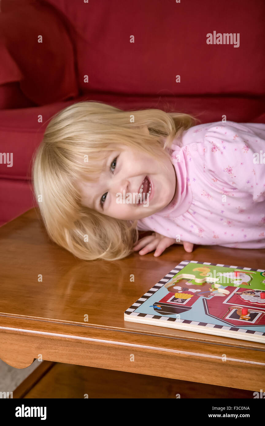 Twenty-two month old toddler girl laughing while putting a puzzle ...