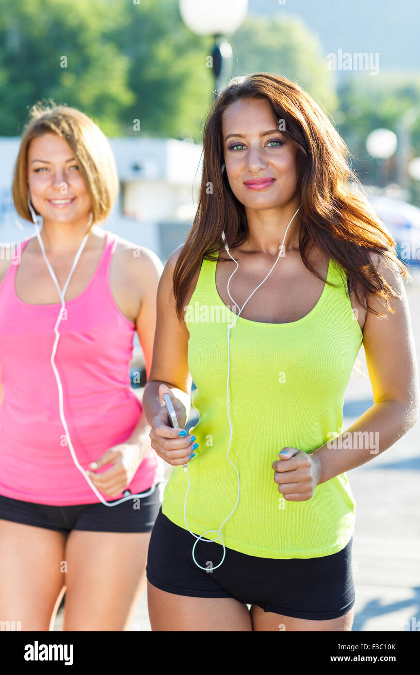 Two cute young girls jogging outdoors Stock Photo - Alamy