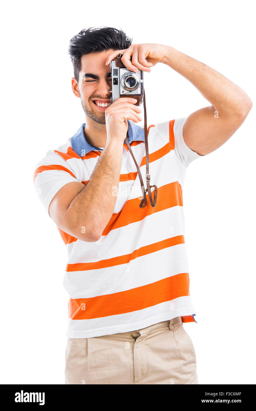 Handsome young man photographing with a vintage camera, isolated over ...