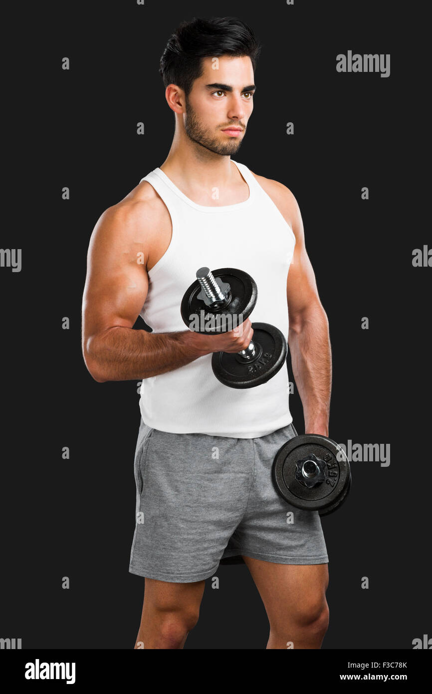 Portrait of handsome young man lifting weights, isolated over a gray ...