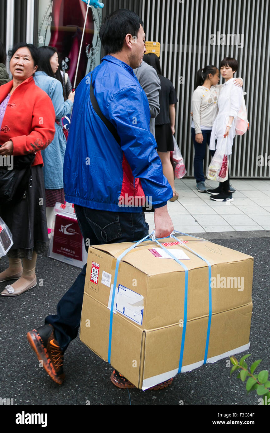 A Chinese tourist holds his shoppings in Shinjuku shopping district ...