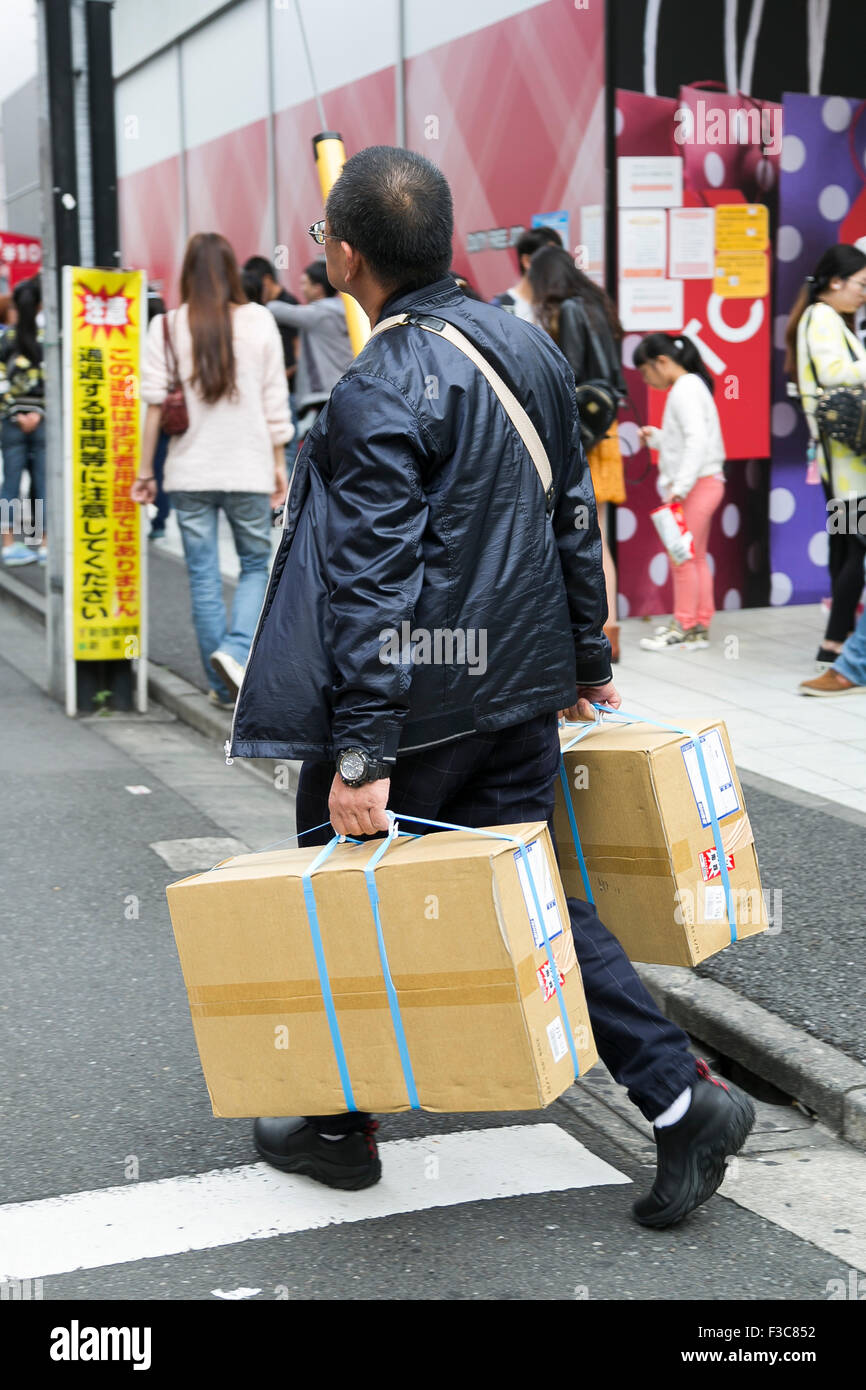 A Chinese tourist holds his shoppings in Shinjuku shopping district ...