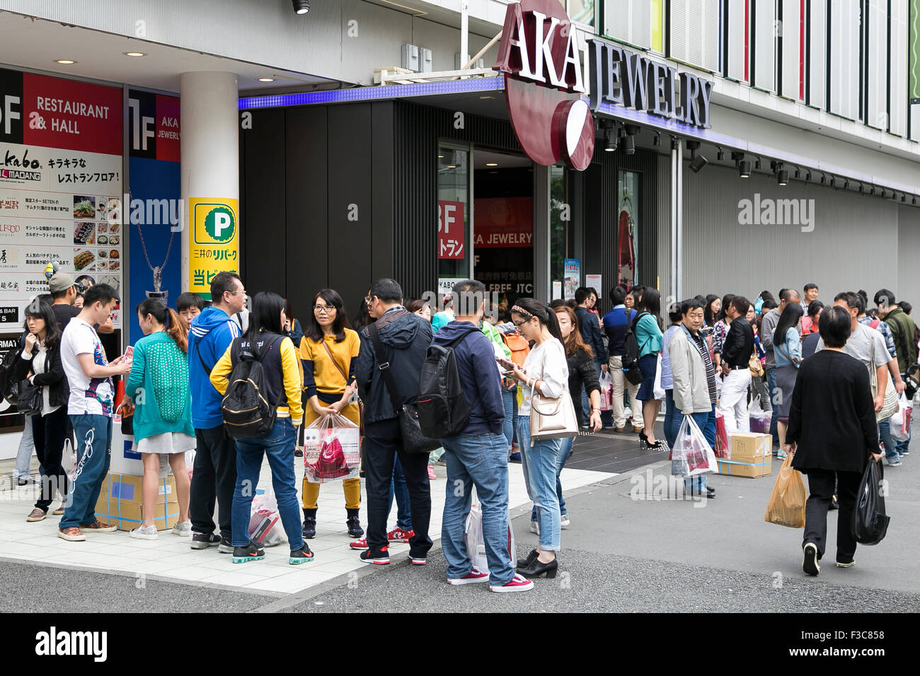 Chinese tourists hold their shoppings in Shinjuku shopping district ...