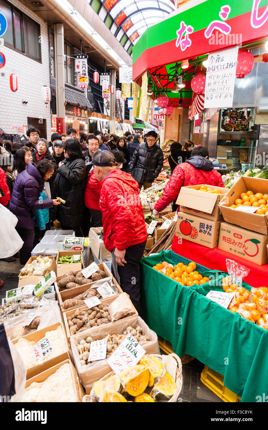 View along a crowded green grocer shop with outside stalls in the busy ...