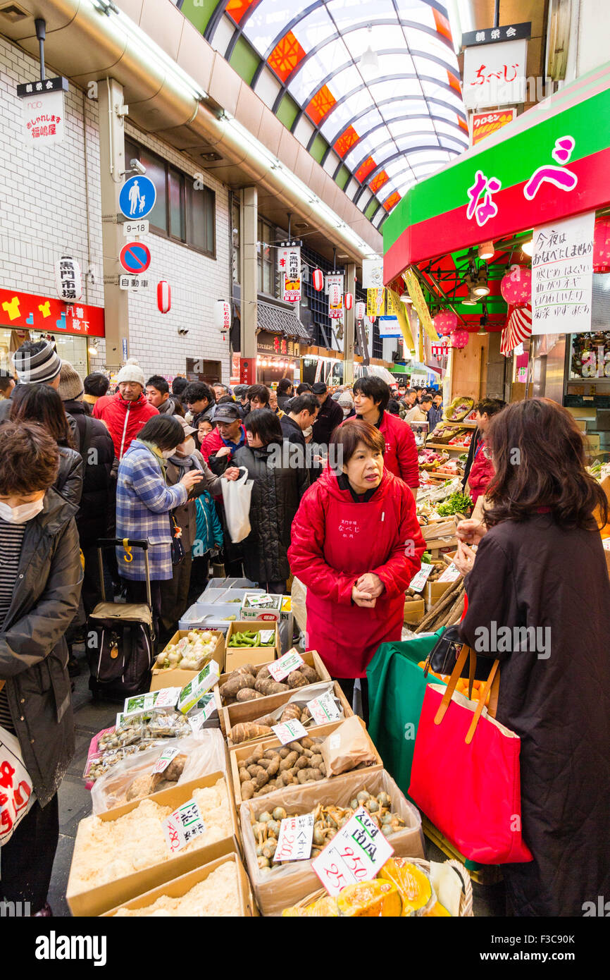 View along a crowded green grocer shop with outside stalls in the busy ...