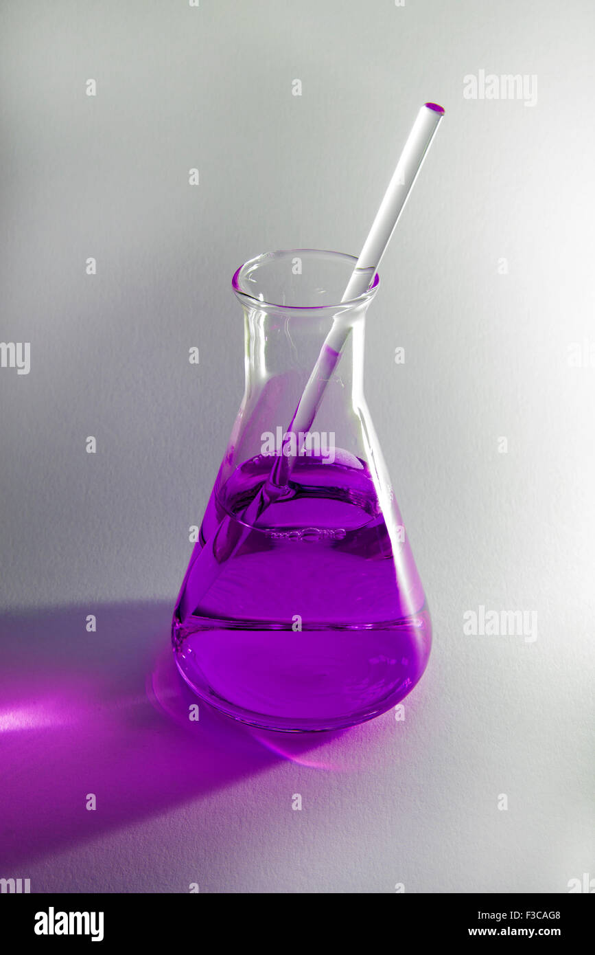 Science flask containing a purple chemical on a plain background Stock ...