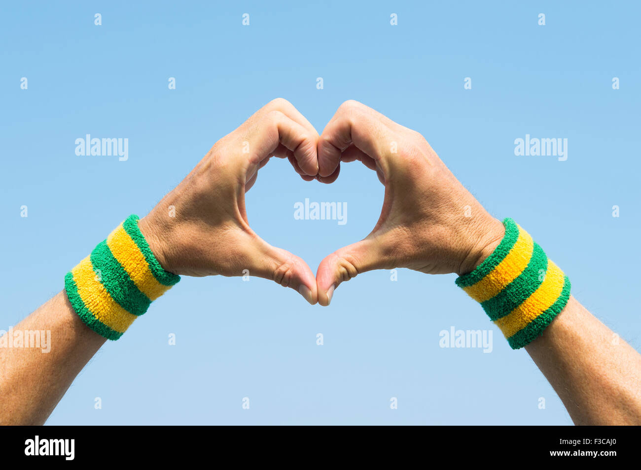 Brazilian athlete making hand heart with Brazil colors wristbands ...