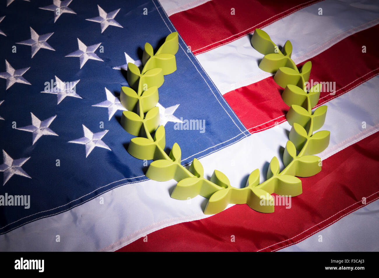 Green laurel wreath sits on the red, white, and blue stars and stripes ...
