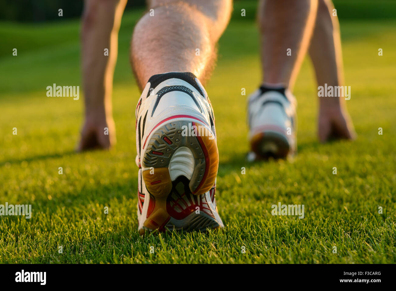 Runner feet running on grass Stock Photo - Alamy