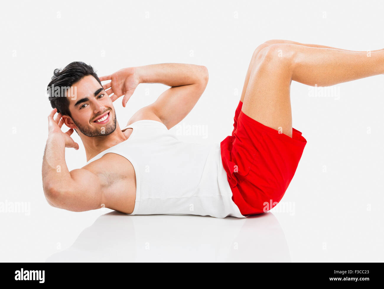 Athletic young man doing ABS, isolated over a gray background Stock ...