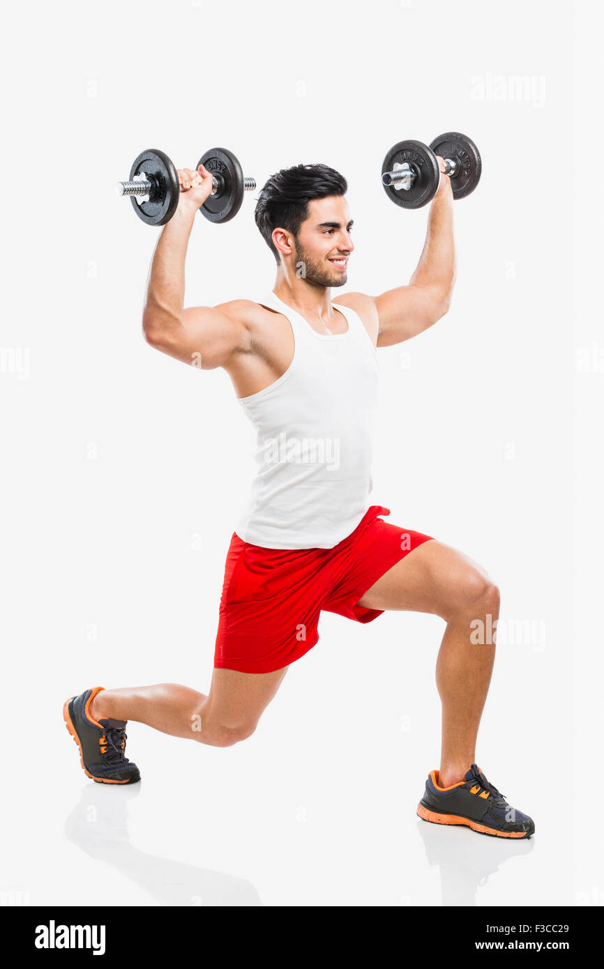Portrait of handsome young man lifting weights, isolated on white ...